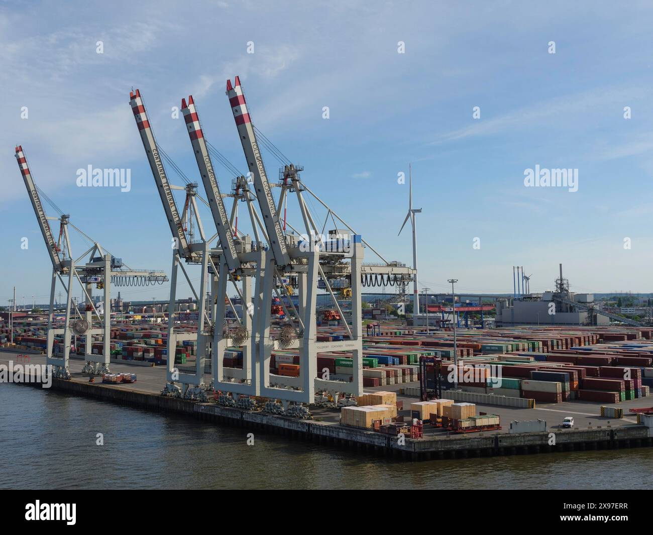 Large harbour cranes lifting containers in an industrial harbour while ...