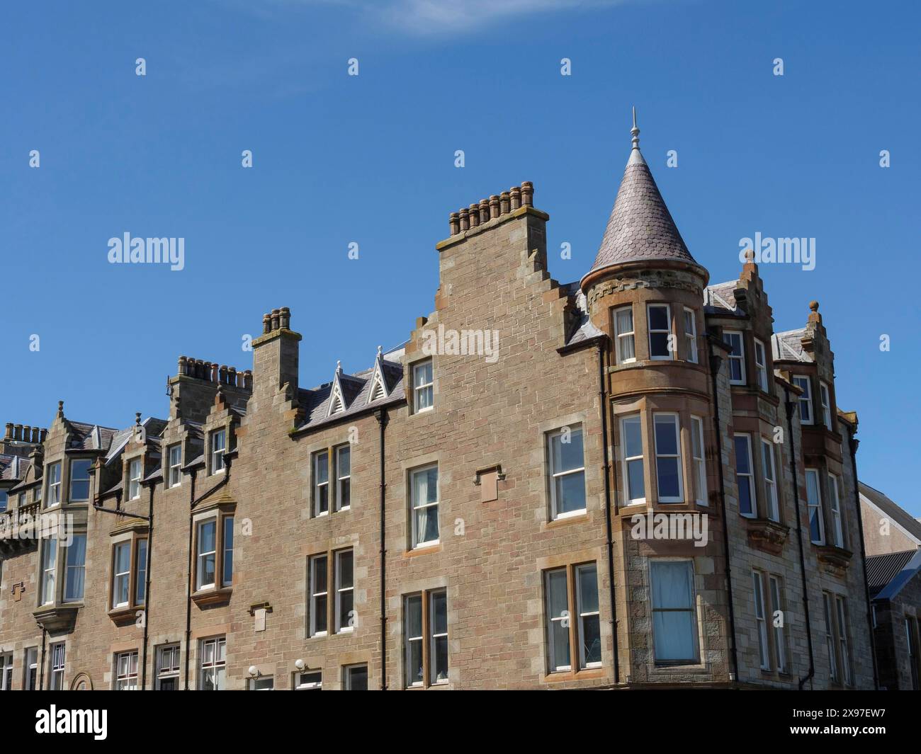Tall historic building with many chimneys and a prominent tower under a ...