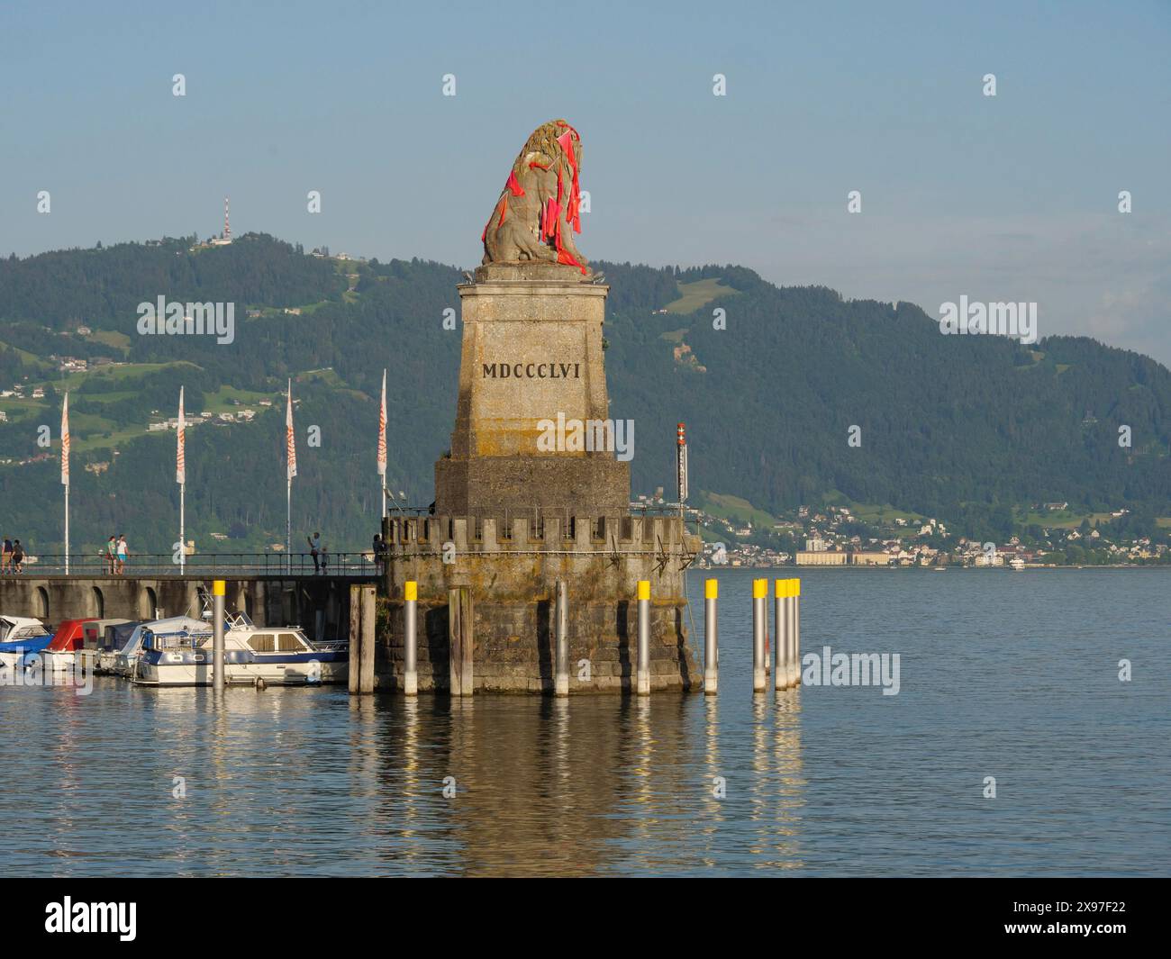 Stone sculpture of a lion at the harbour with surrounding boats and ...