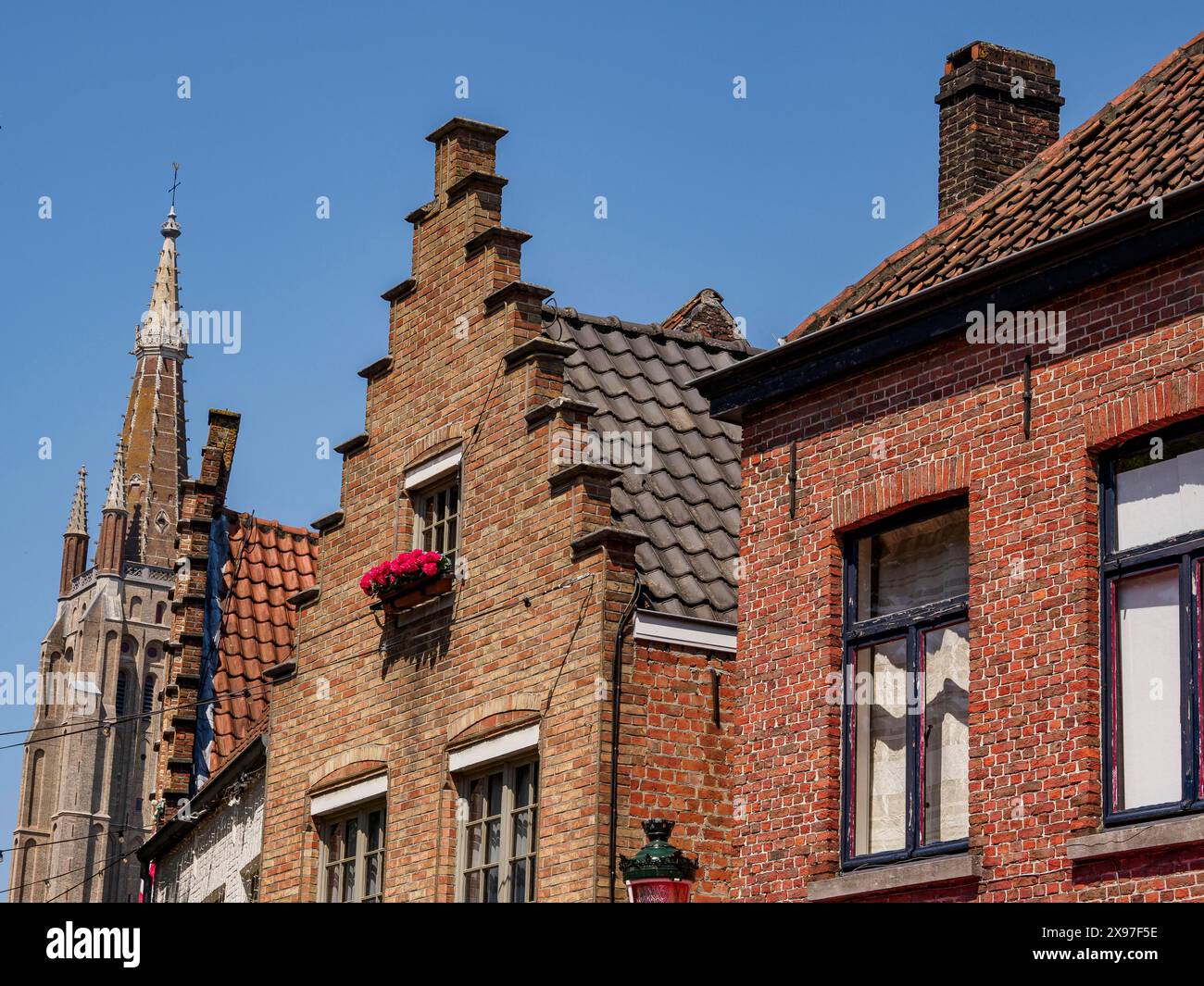 Row of historic brick houses with windows and a large church tower ...