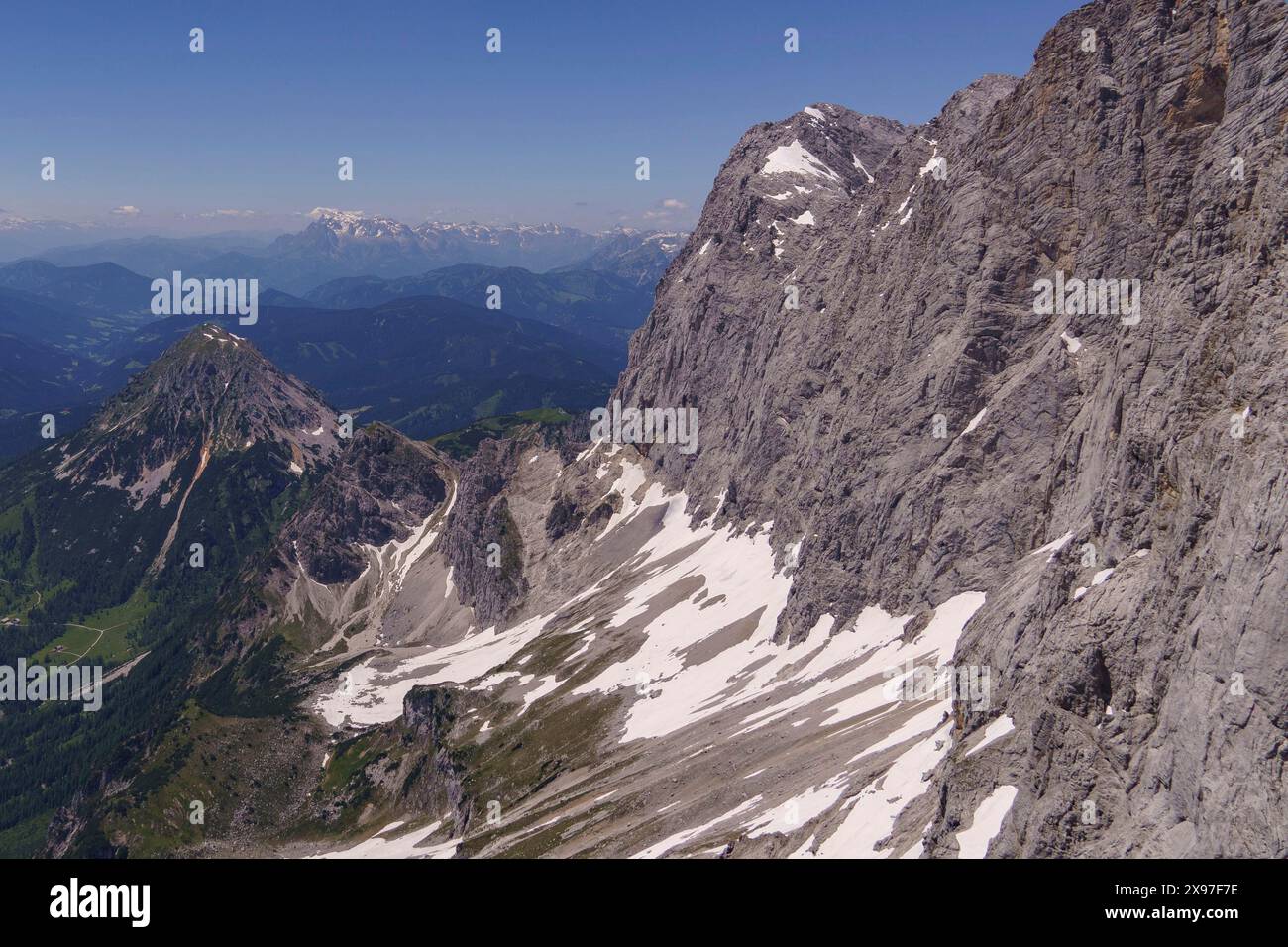 Steep rock face of the Alps with remnants of snow indicates summer ...