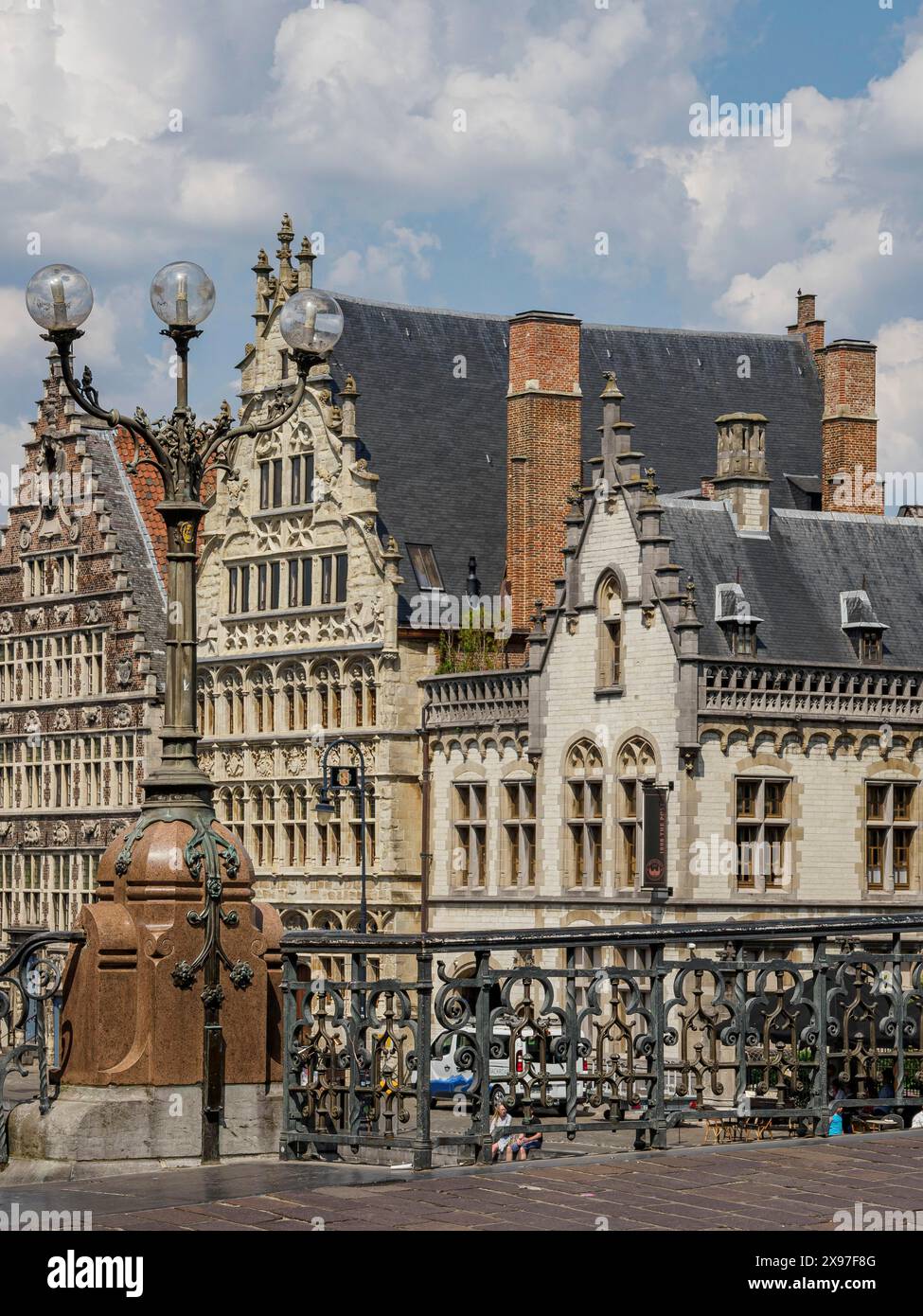 Historic gothic buildings and an ornate street lamp under a blue sky ...