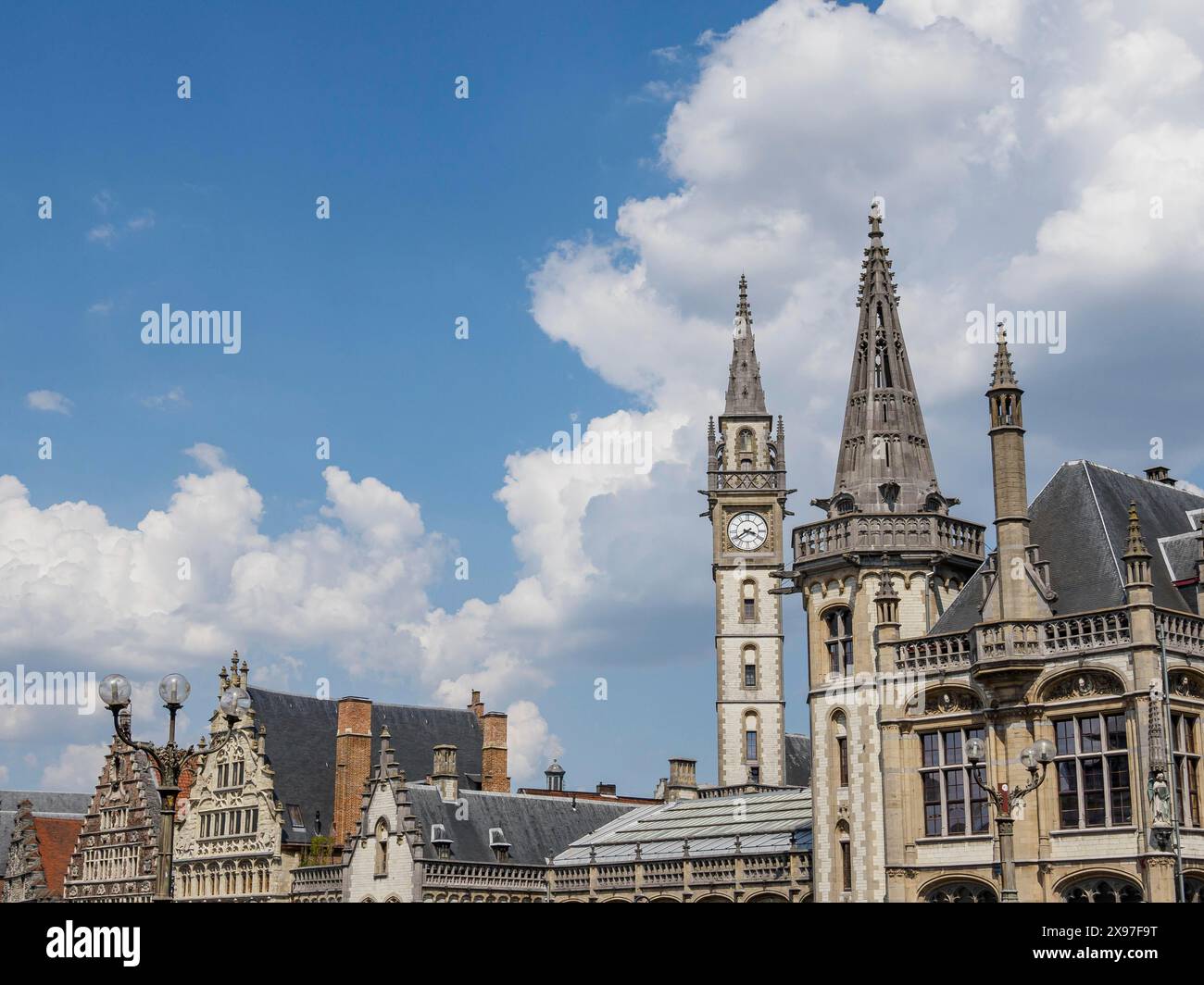Gothic buildings and tall clock tower, under a clear blue sky with ...