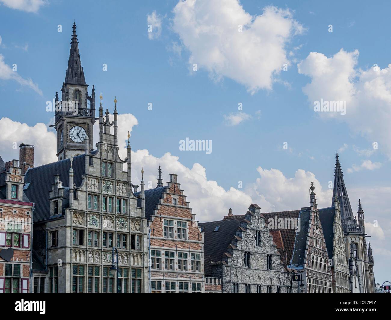 Detailed view of gothic buildings and church tower under cloudy sky ...
