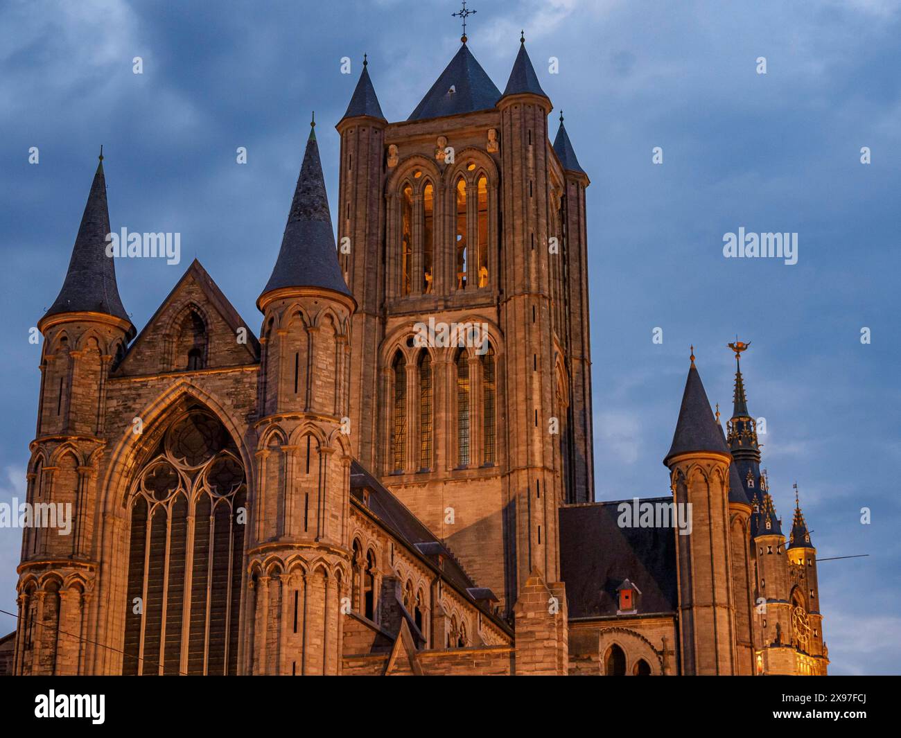 A gothic church with striking towers and illuminated windows at dusk ...