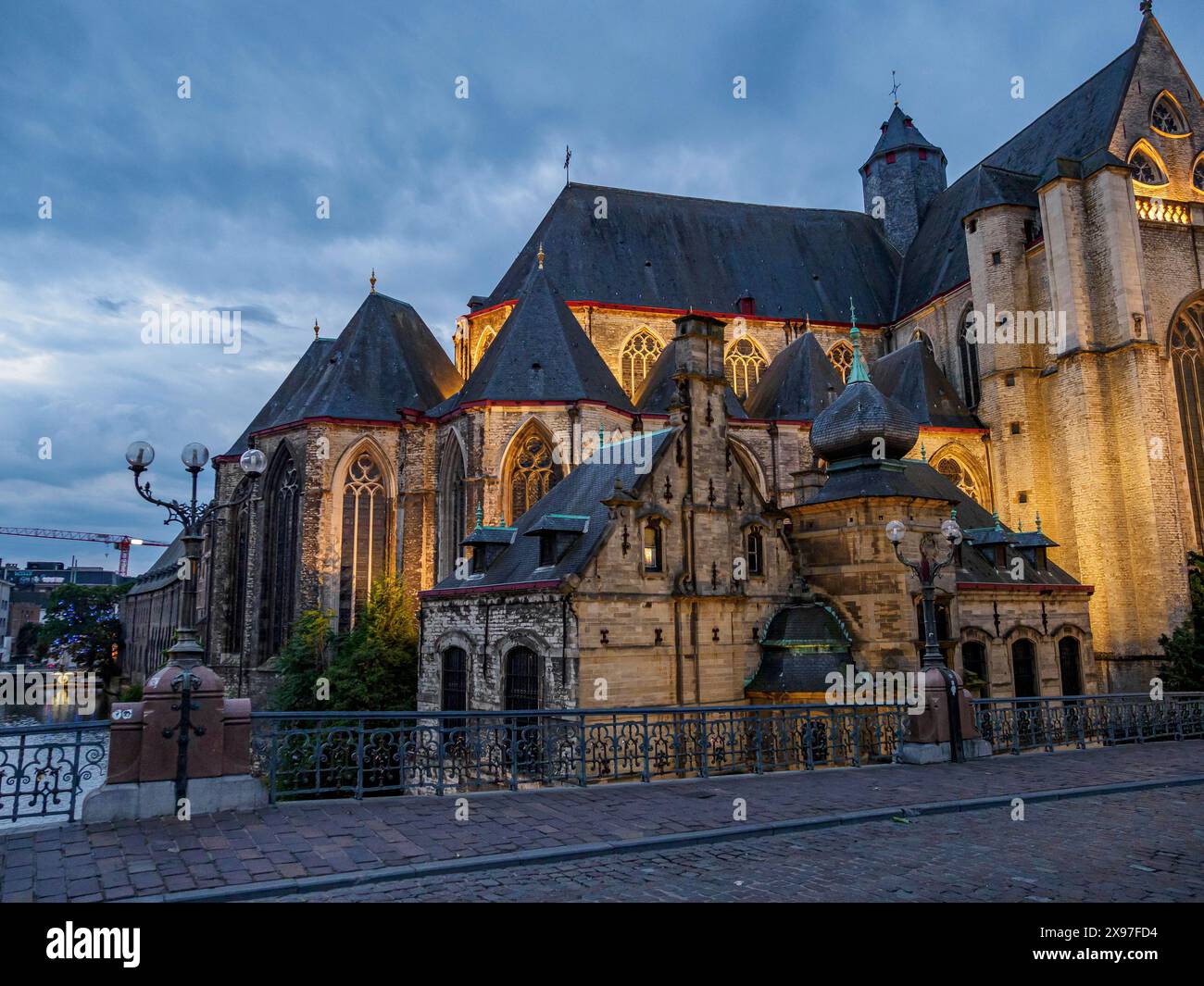 A gothic church at night with lighting, surrounded by old buildings and ...