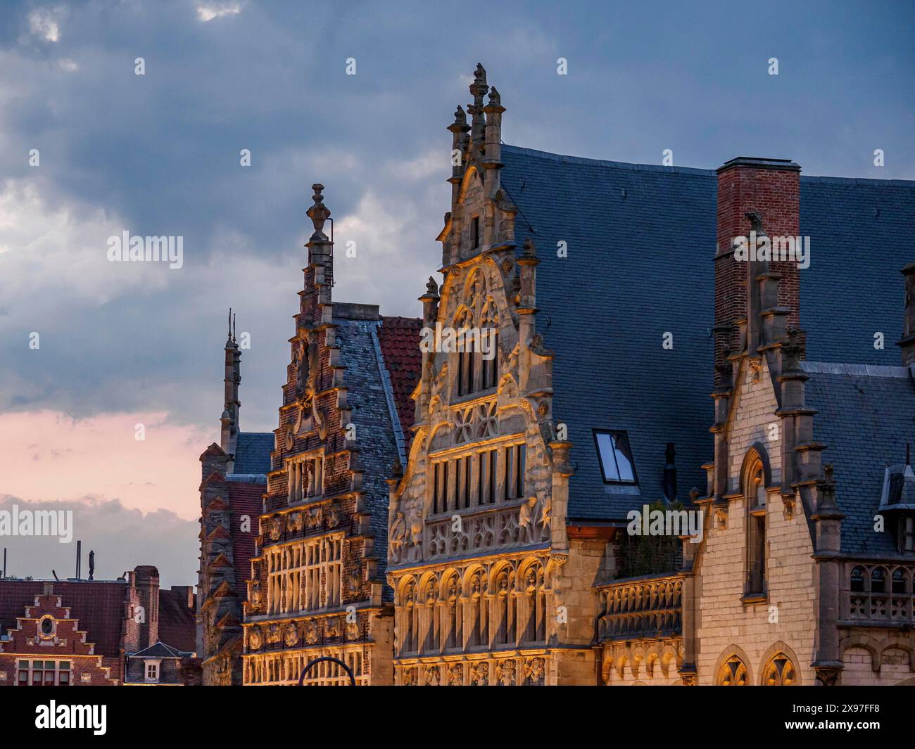 Ornate historic buildings with gabled roofs in Bruges in the light of ...