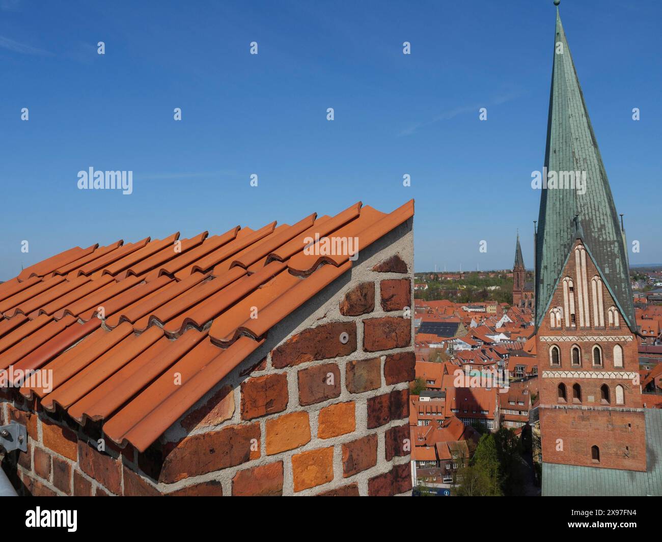 Brick roof and church tower dominate the view of a medieval town with ...