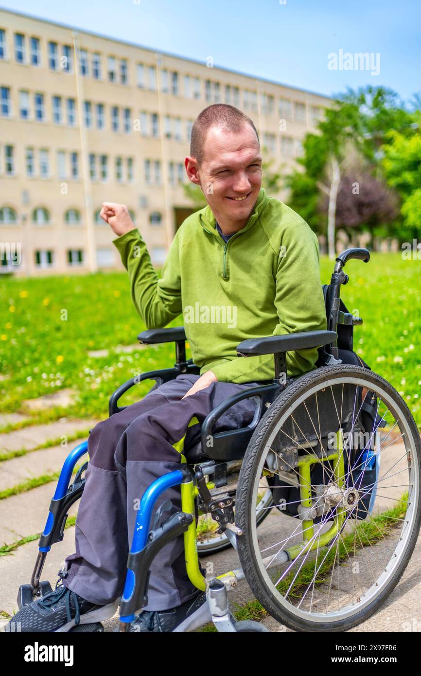 Vertical exterior portrait of a disabled man smiling sitting in the ...
