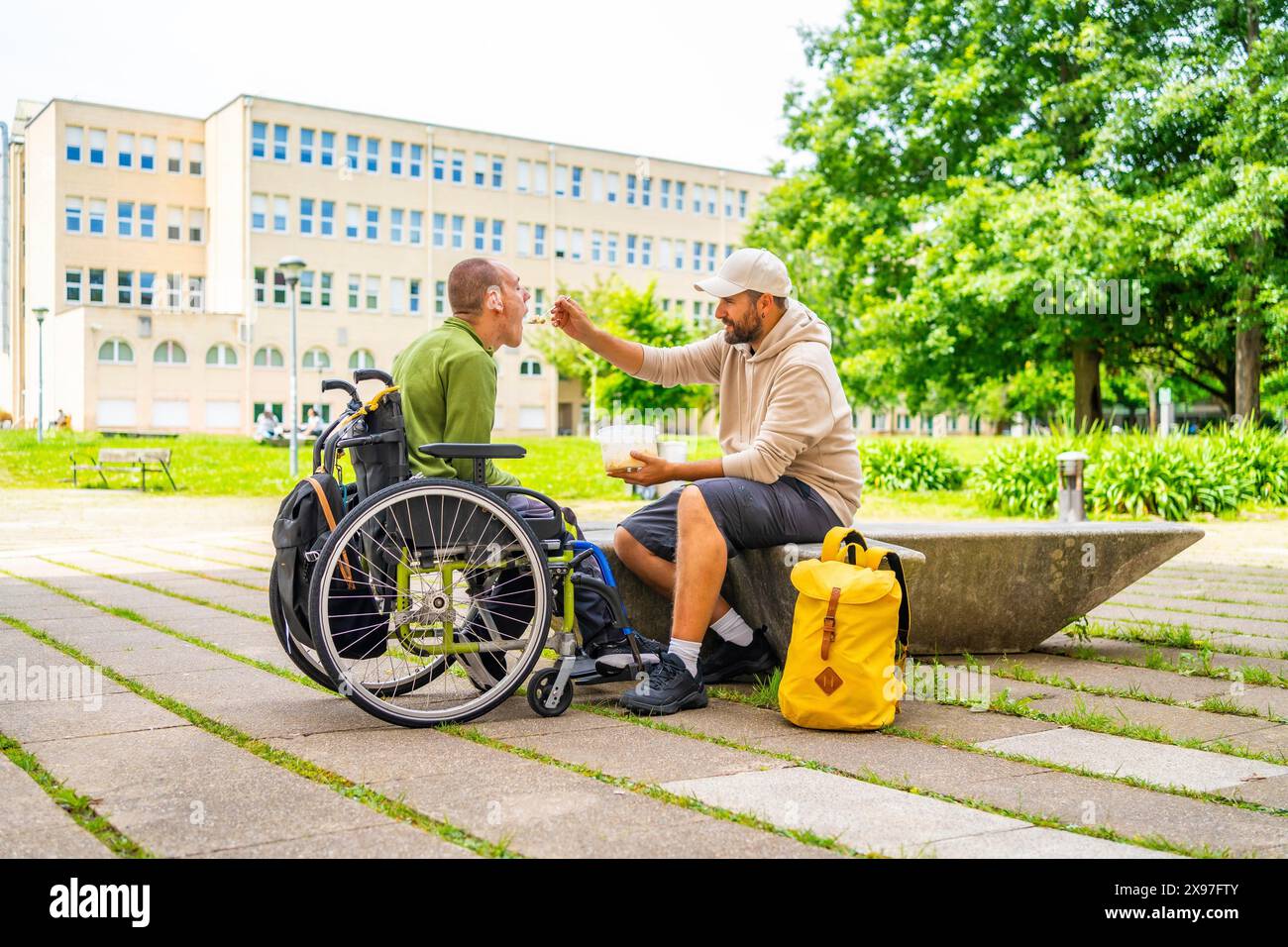 Full length photo of a caucasian adult college student feeding a friend ...