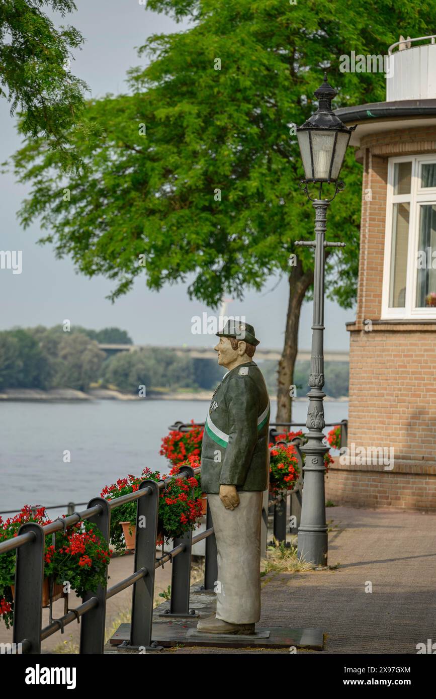 Statue of a man in uniform next to a walkway on the riverbank with ...
