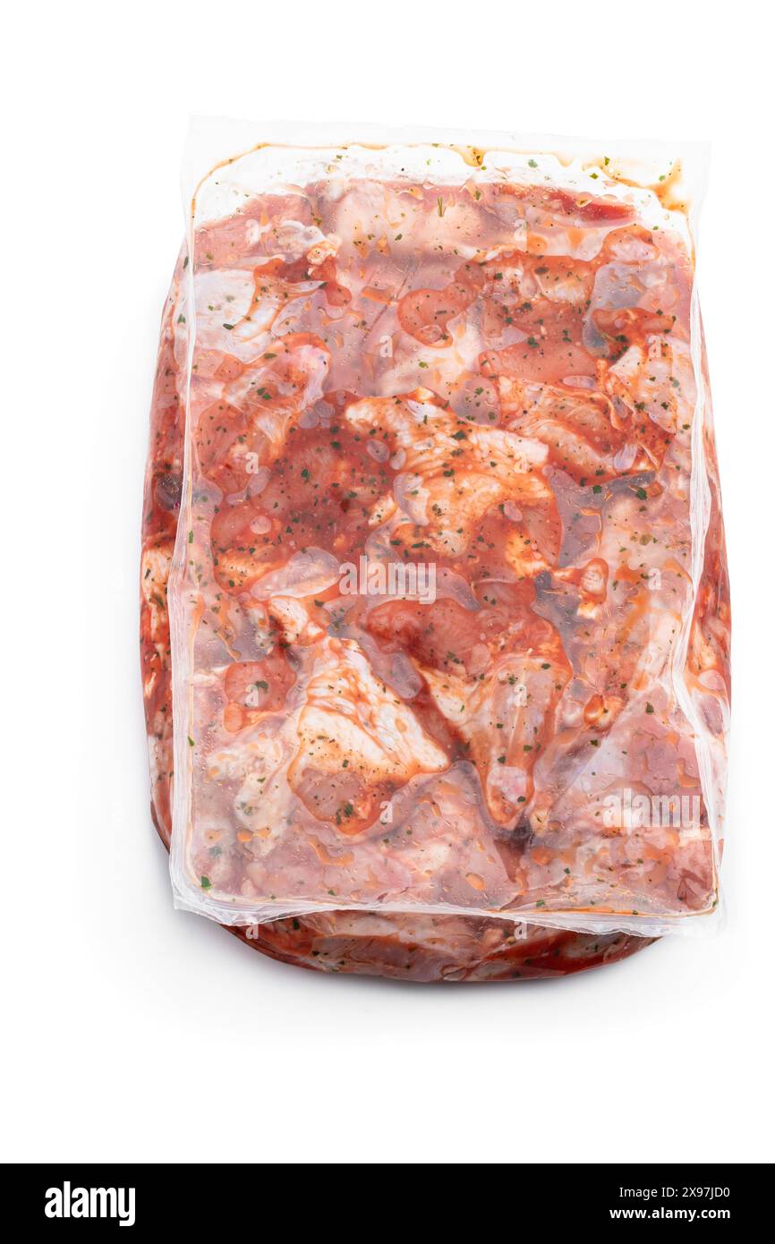 Raw marinated chicken meat in vacuum packaging on a white background ...