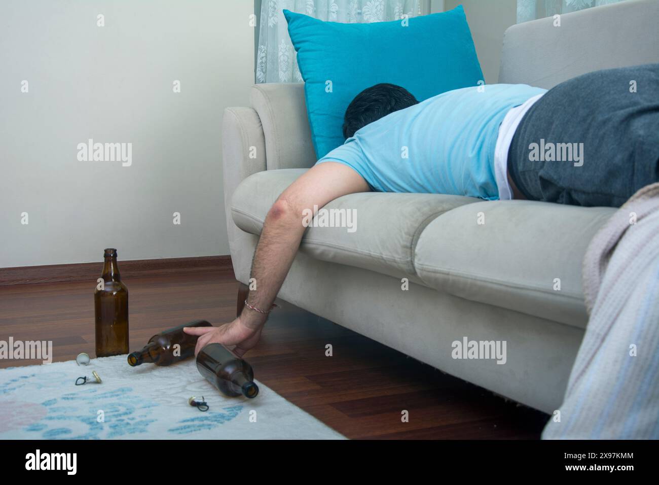 Man passed out due to alcohol is sleeping on the sofa Stock Photo - Alamy
