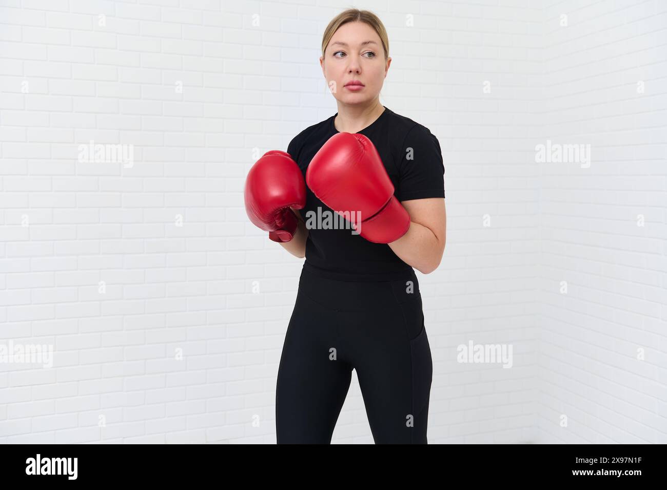 European young woman 30s, fighter boxer in red boxing gloves, standing ...
