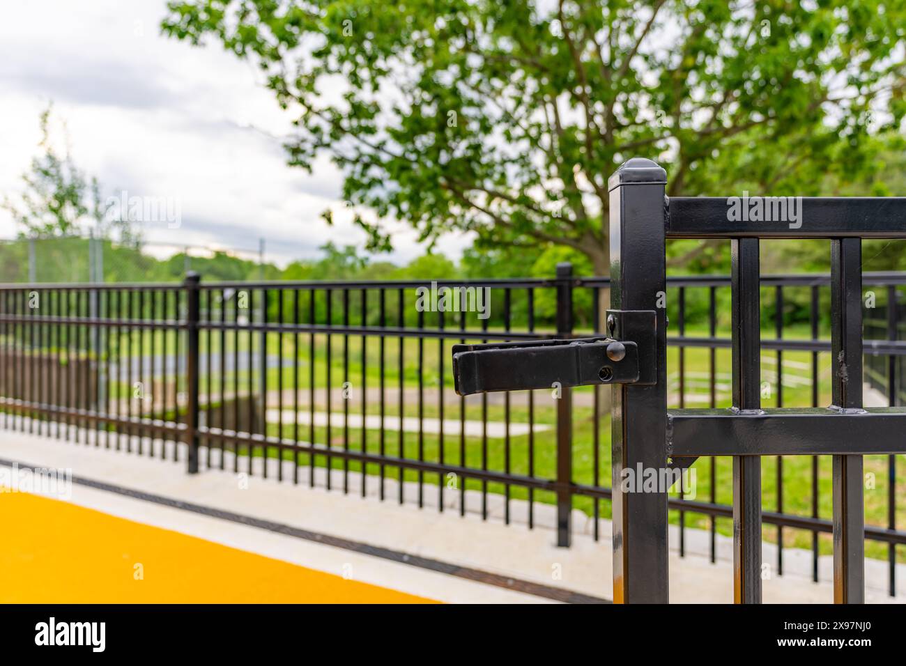 Close-up photo of an ornamental black metal fence gate latch at a ...