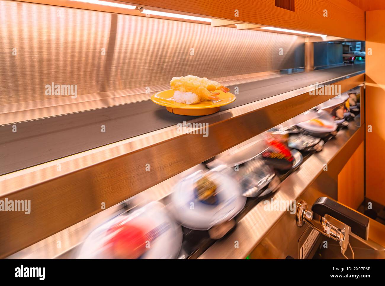Long exposure photography of a bustling revolving sushi bar capturing ...
