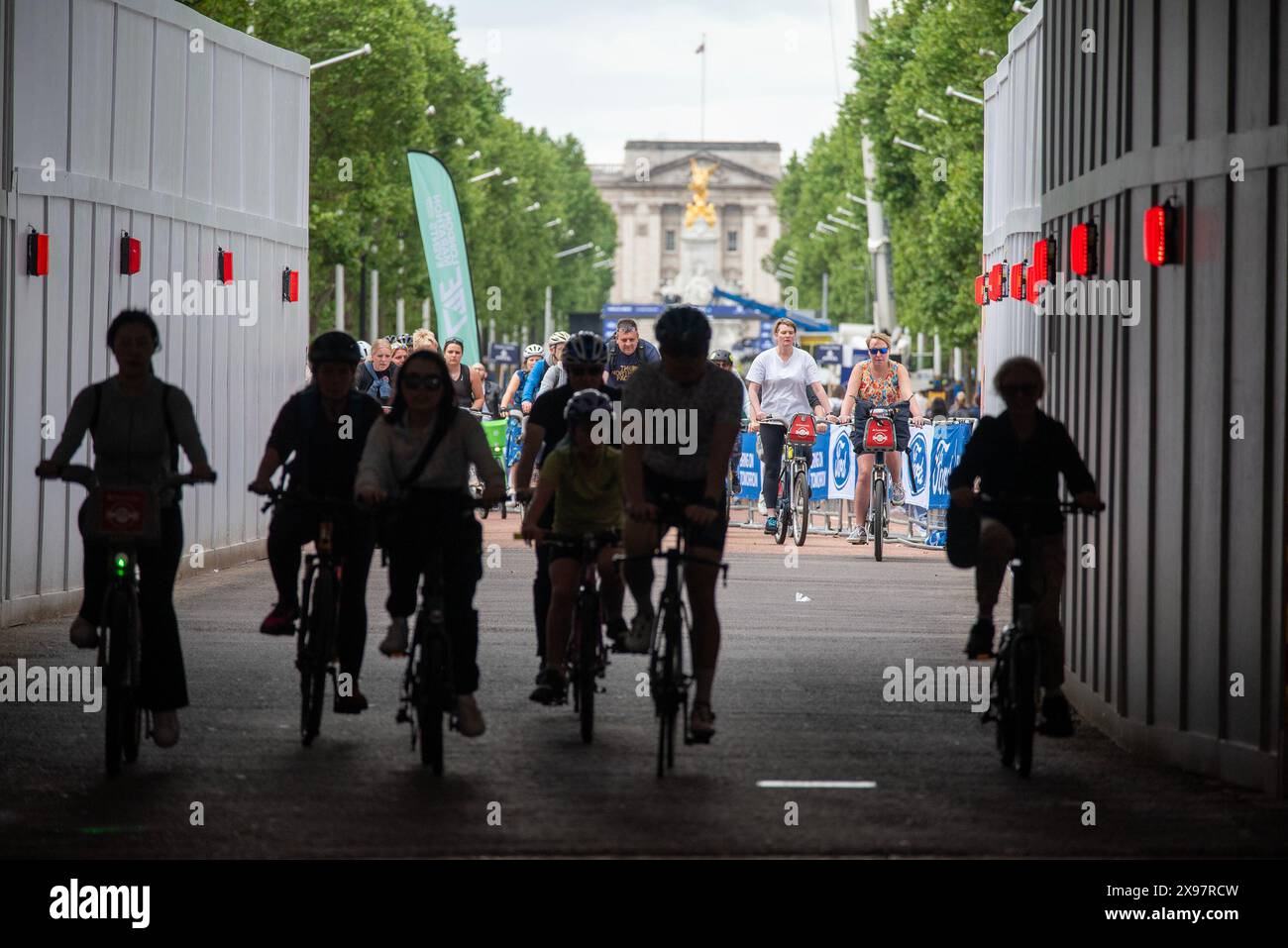 London, UK. 26th May, 2024. Cyclists ride under the Admiralty Arch ...