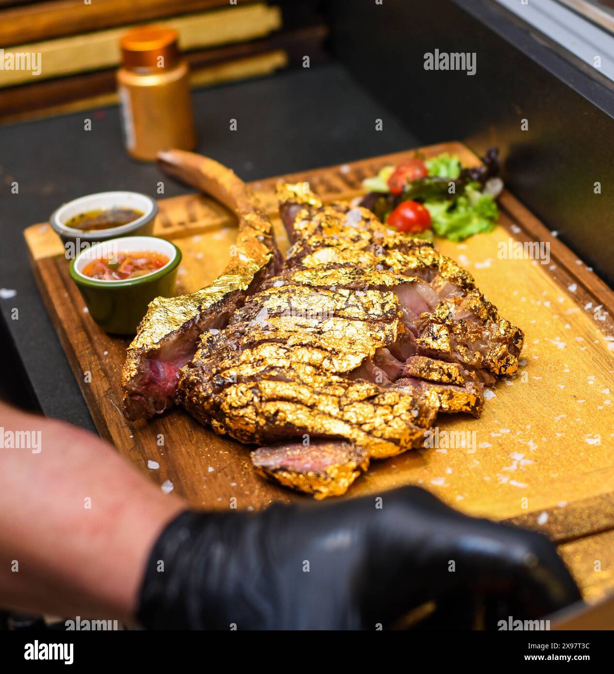 Premium beef tomahawk coated in edible gold Stock Photo - Alamy
