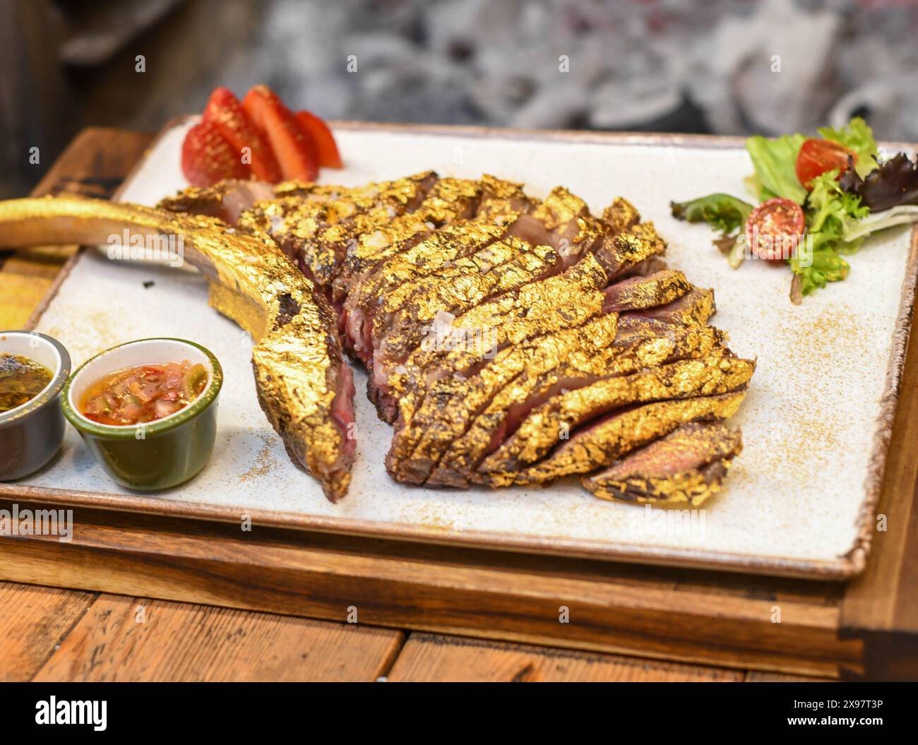 Premium beef tomahawk coated in edible gold Stock Photo - Alamy