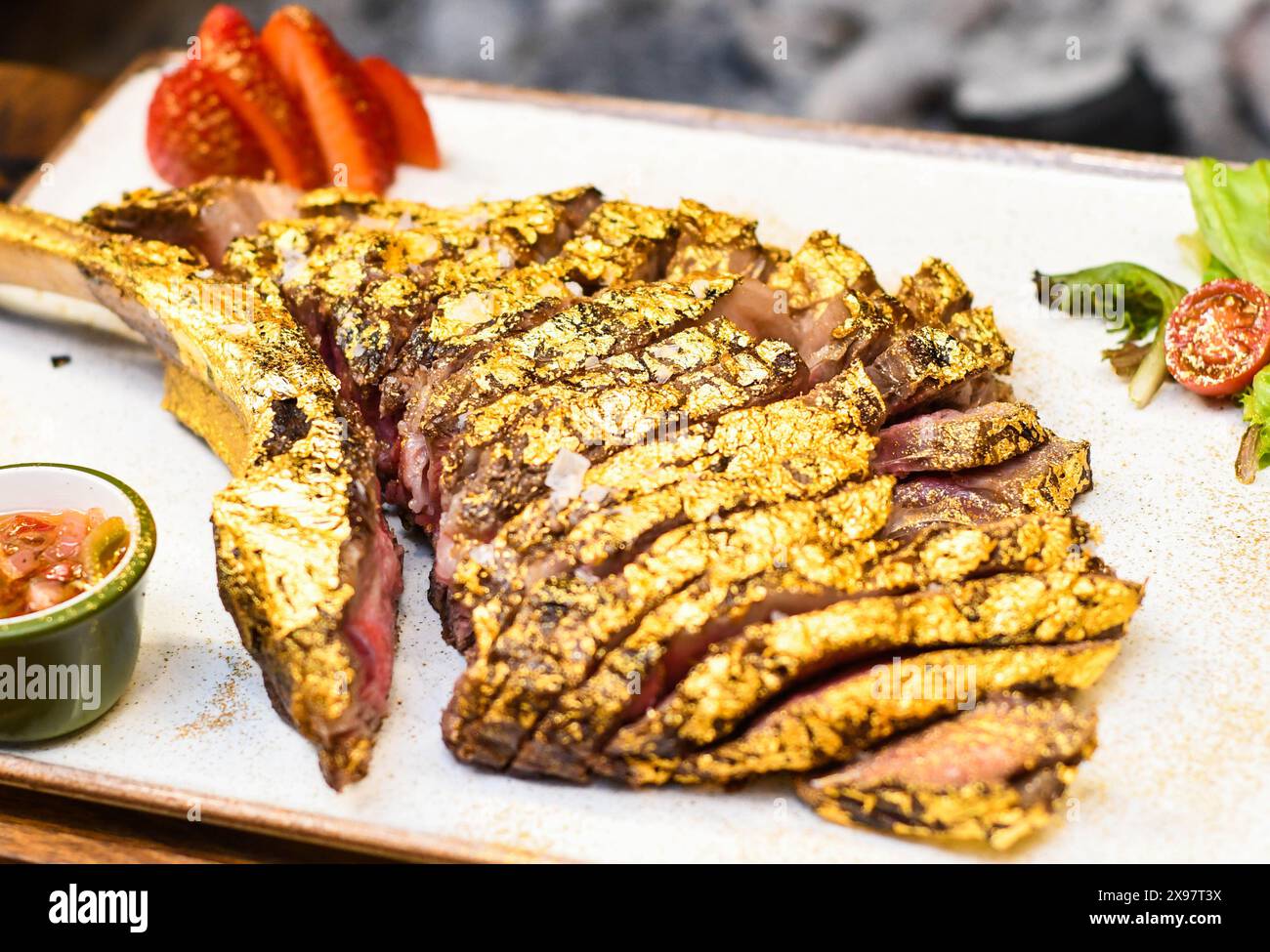 Premium beef tomahawk coated in edible gold Stock Photo - Alamy