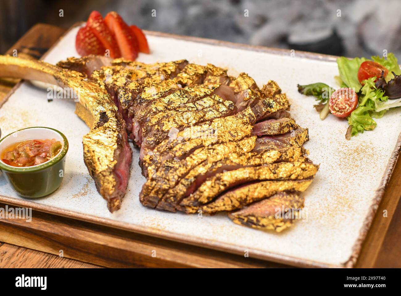 Premium beef tomahawk coated in edible gold Stock Photo - Alamy