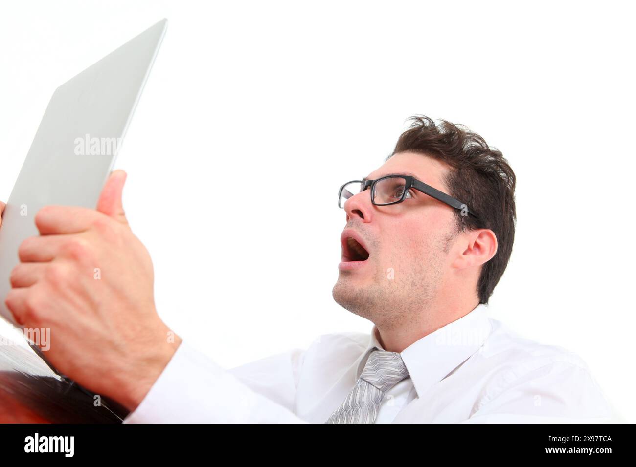 stressed out man with glasses on white background looking at laptop ...