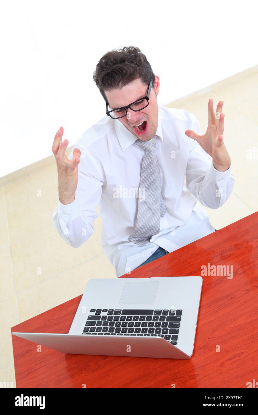 stressed out man with glasses on white background looking at laptop ...