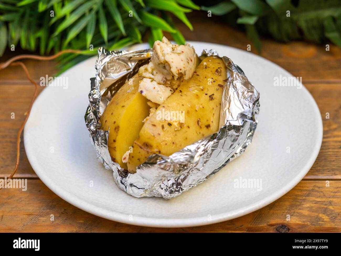 Potato roasted over fire with butter Stock Photo - Alamy