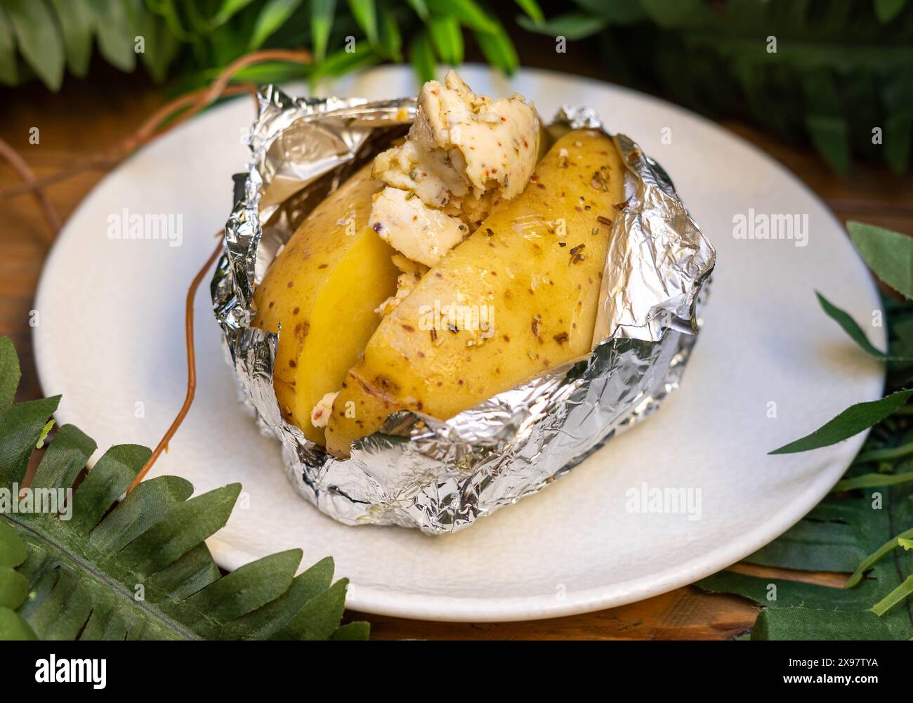Potato roasted over fire with butter Stock Photo - Alamy