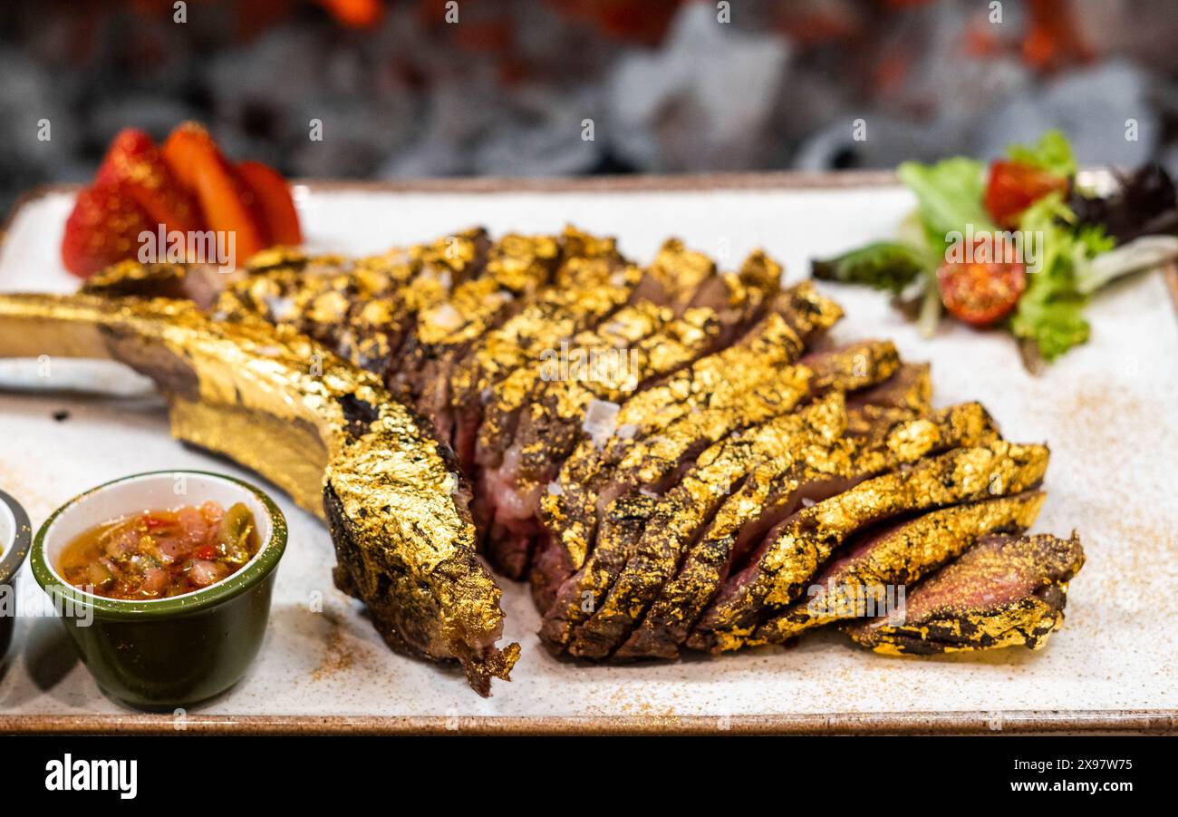 Premium beef tomahawk coated in edible gold Stock Photo - Alamy