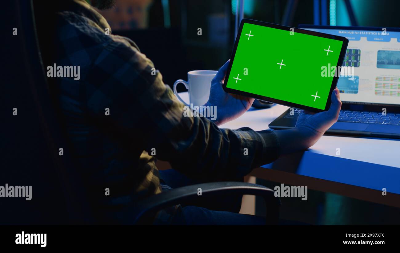 Man in home office checking statistical financial graphs on laptop ...