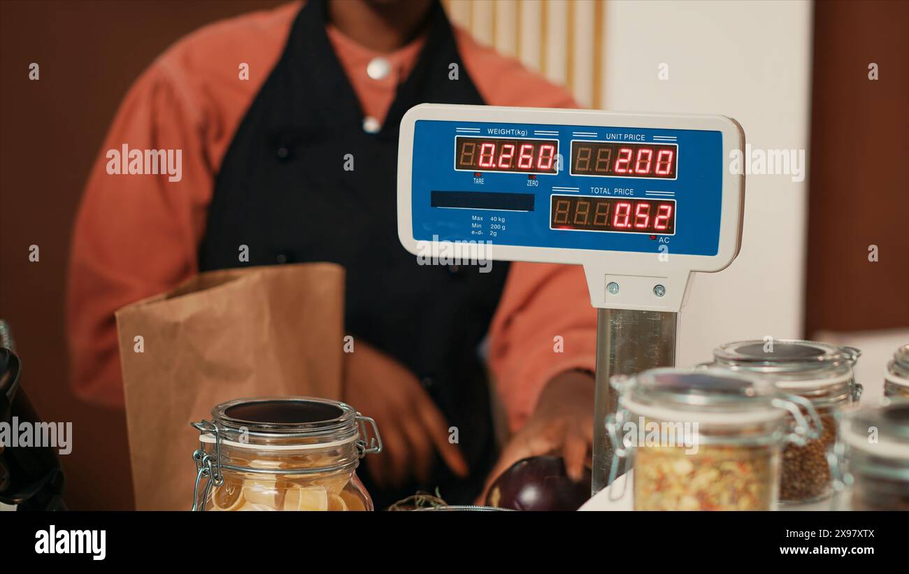 Seller using electronic scale at grocery store cash register, selling ...