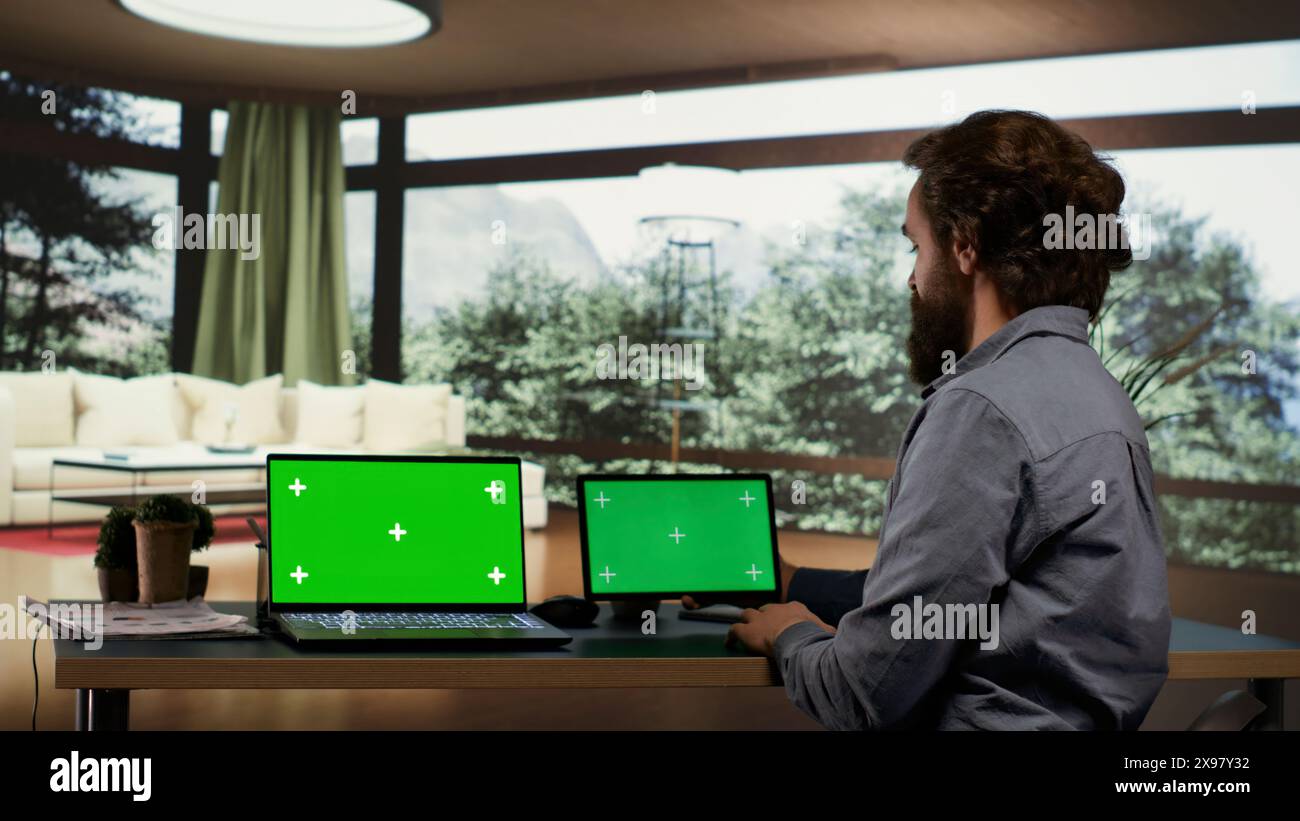 Businessperson using greenscreen displays on devices, sitting at his ...