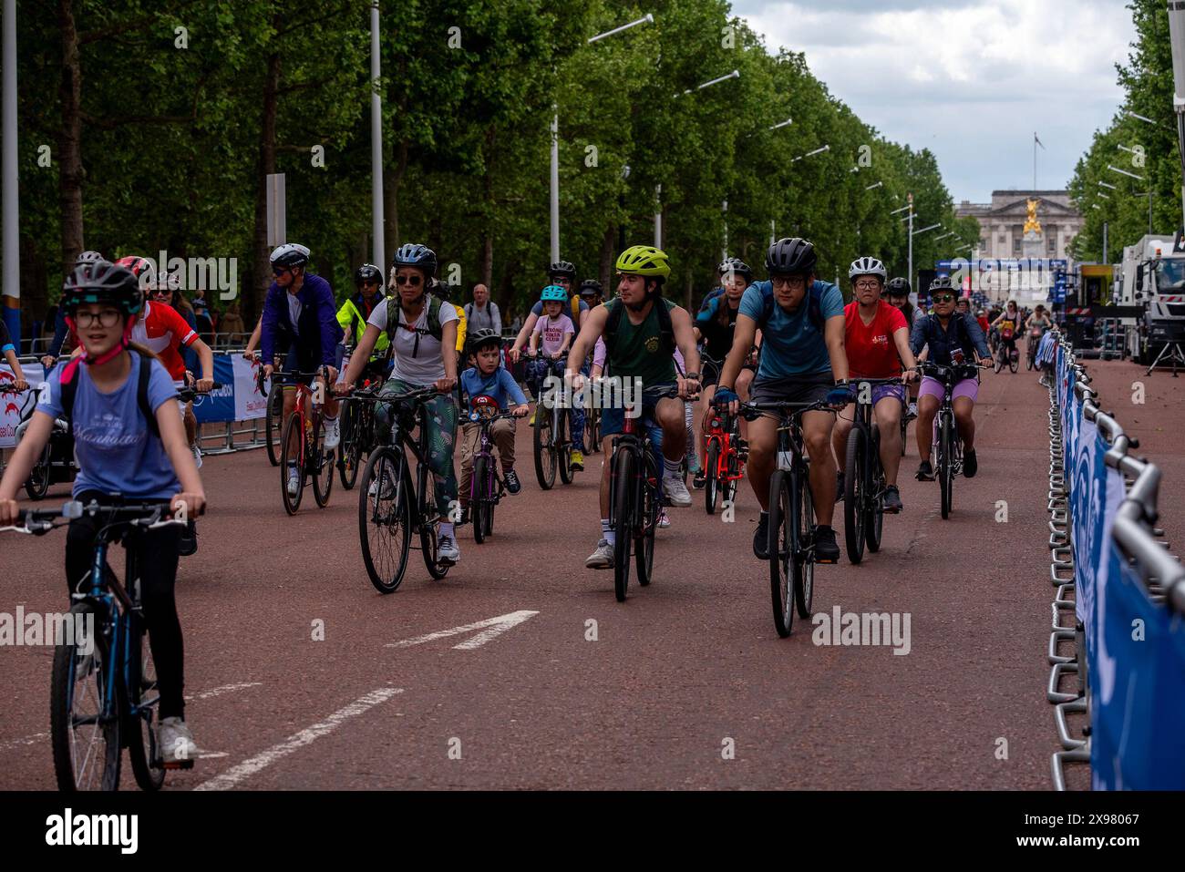 London, UK. 26th May, 2024. Cyclists ride through The Mall in London ...