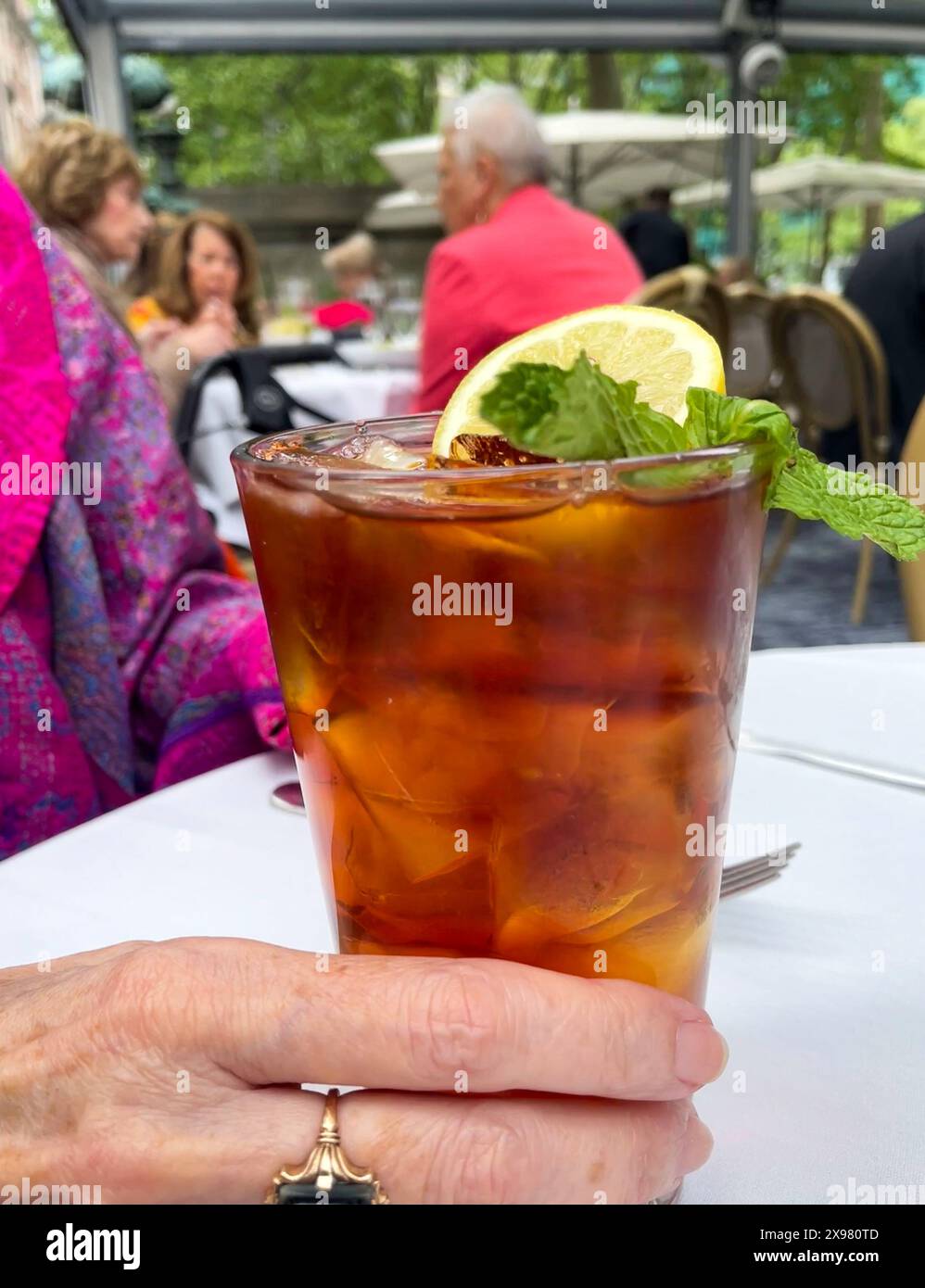 Tall glass of iced tea on a table in the outdoor dining garden at ...