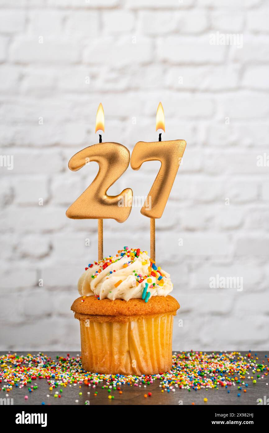 Golden birthday candle number 27 with cupcake - White block wall ...