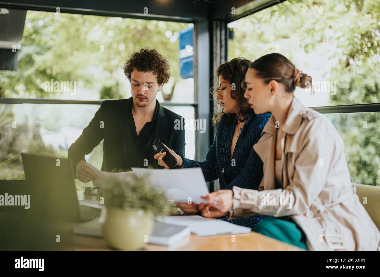 Young business partners collaborating in a coffee bar to create new ...