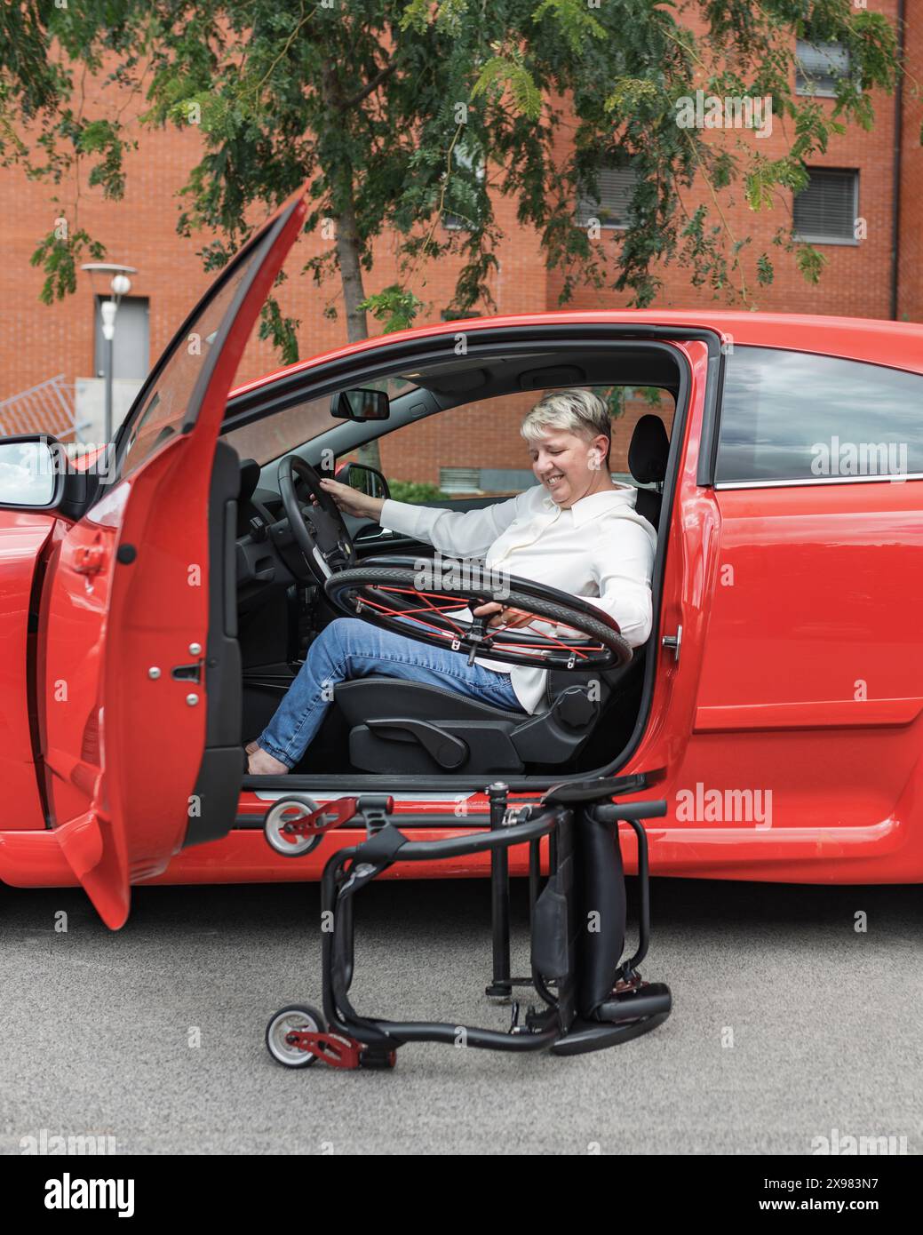 Smiling woman, a driver with a disability sitting in the car with a ...