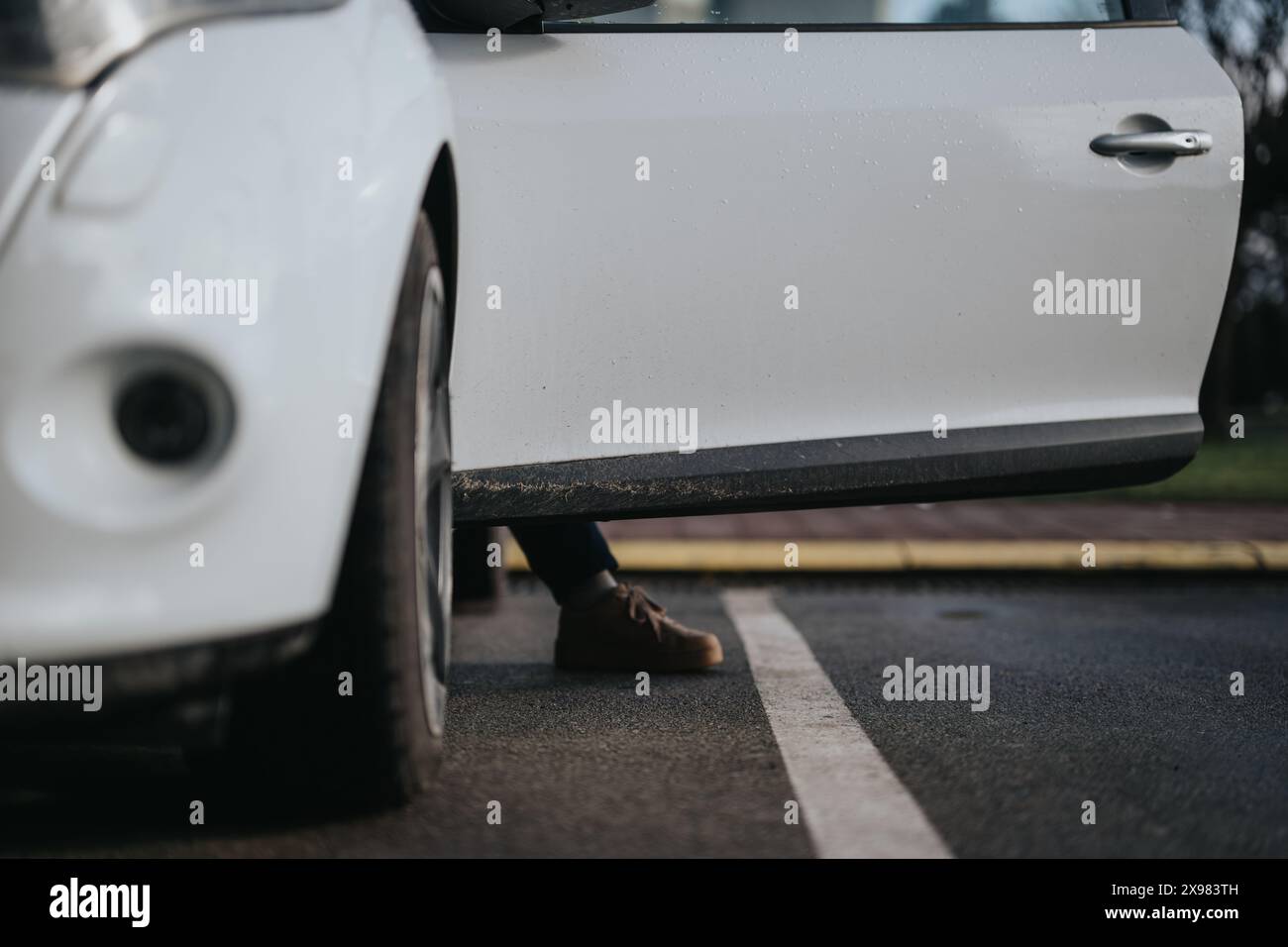 Close-up of dirty white car door with person's legs in background Stock ...