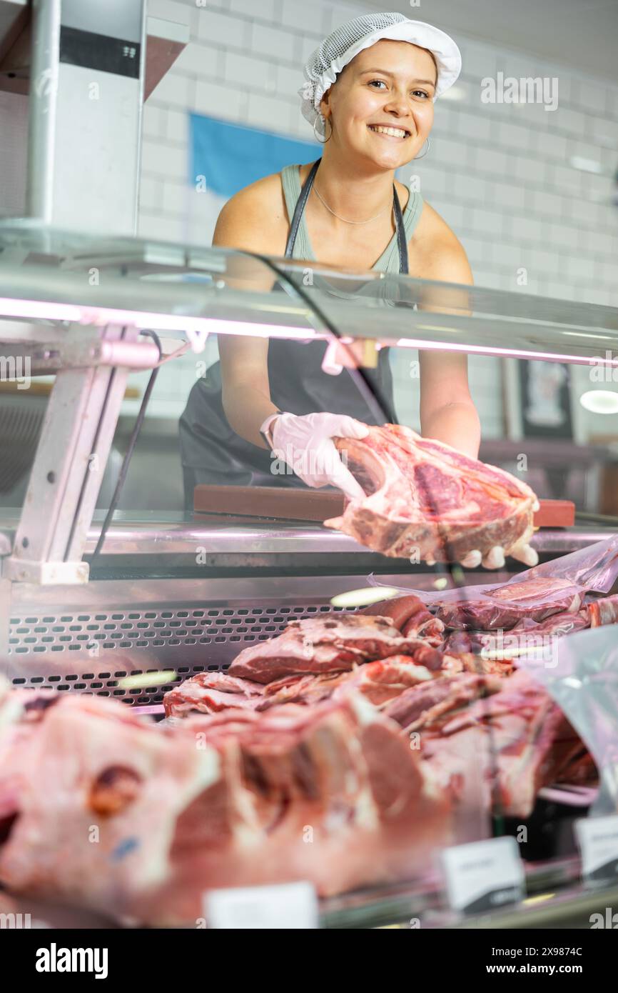 Girl seller works in specialized butcher shop Stock Photo - Alamy