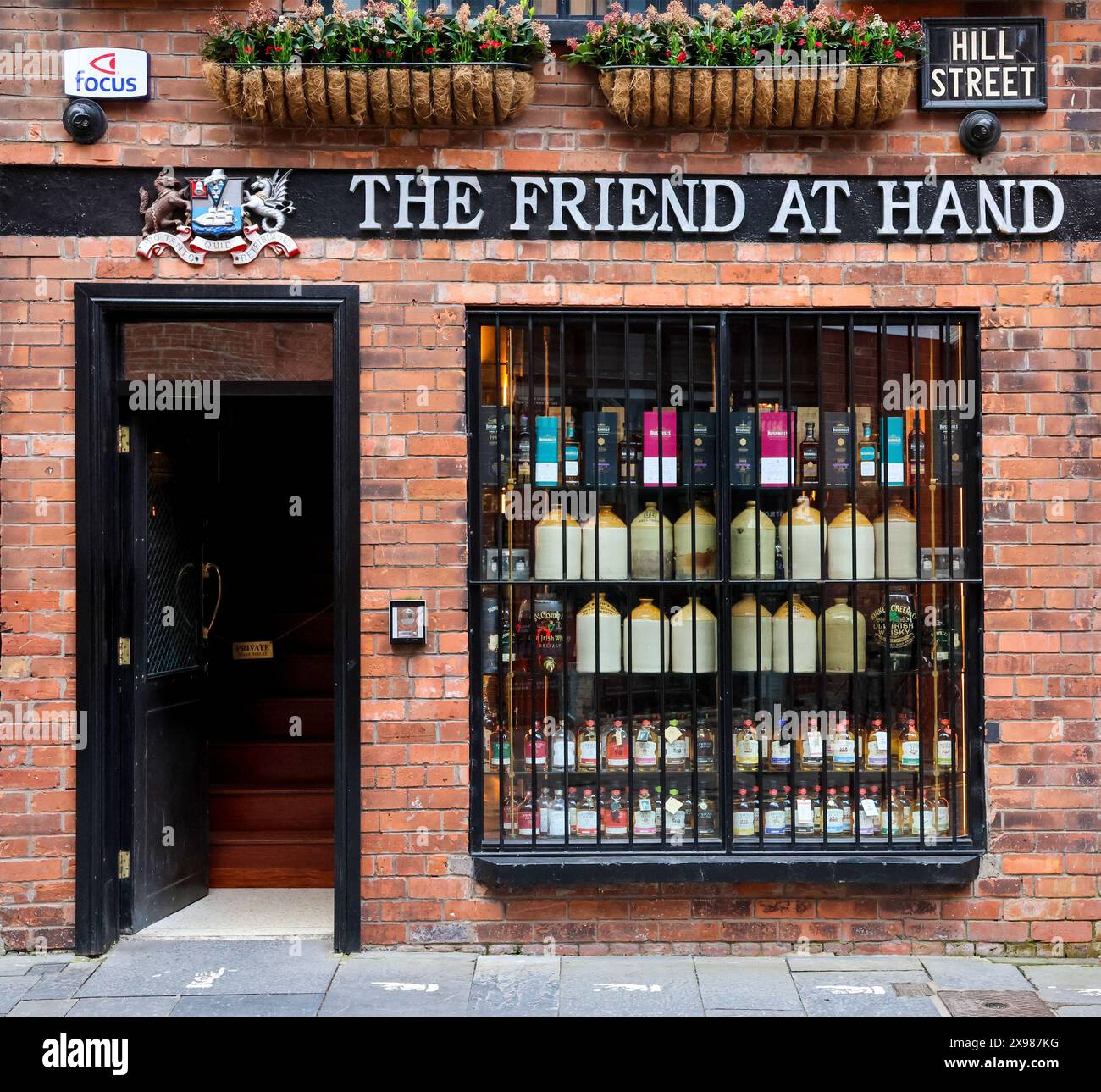 Front entrance and whiskey bottles in window of whiskey shop in Belfast ...