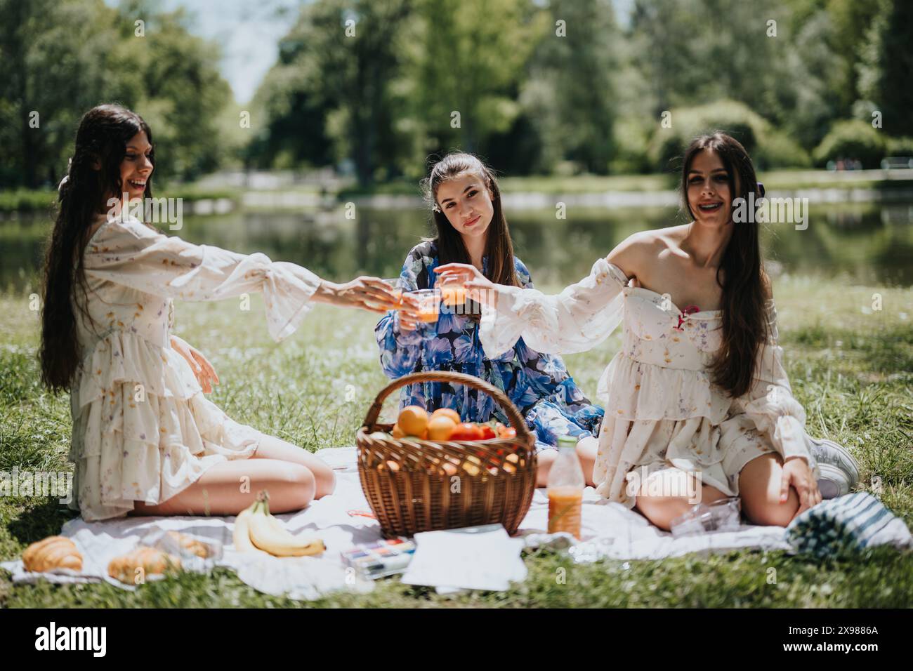 Three friends enjoying a sunny day with a picnic in the park, sharing ...