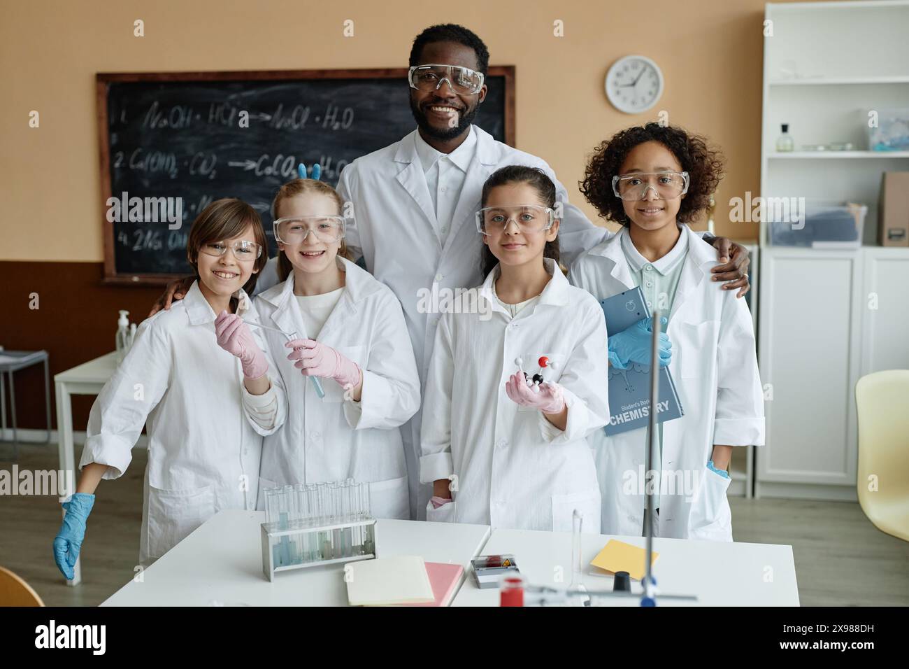 Group portrait of cheerful African American teacher of Chemistry and ...