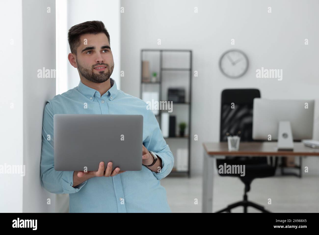 Happy young programmer with laptop in office Stock Photo - Alamy