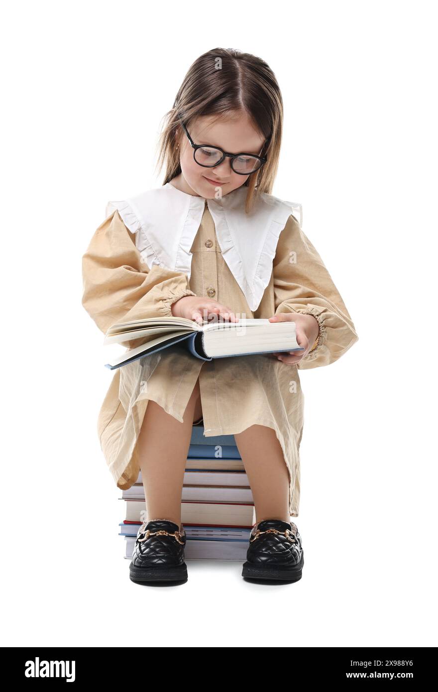 Cute little girl reading on stack of books against white background ...