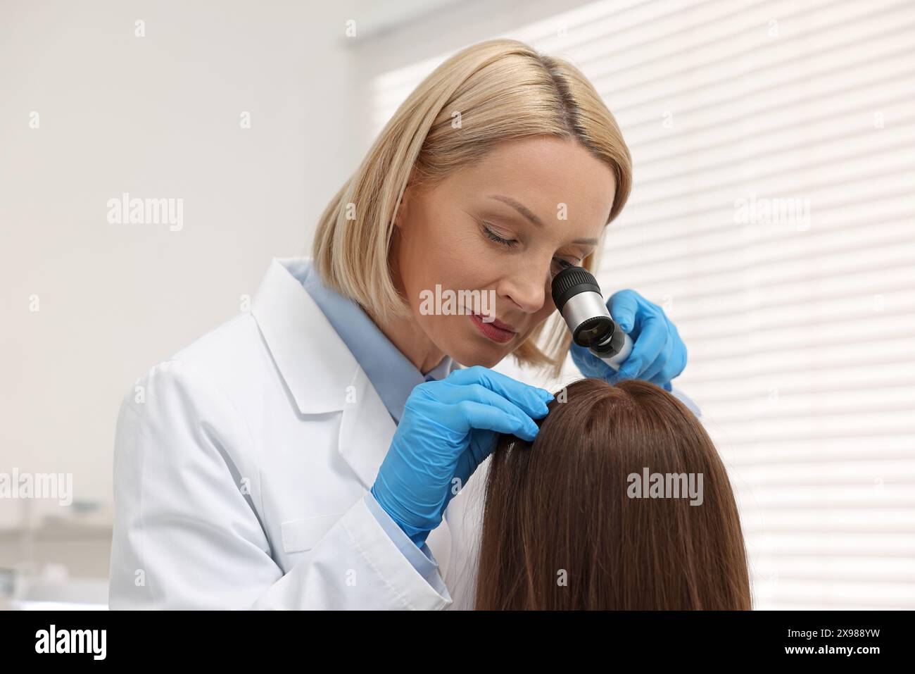 Trichologist with dermatoscope examining patient`s hair in clinic Stock ...