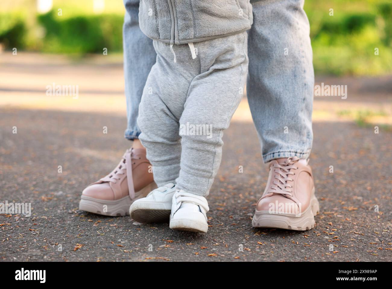 Mother teaching her baby how to walk outdoors, closeup Stock Photo - Alamy
