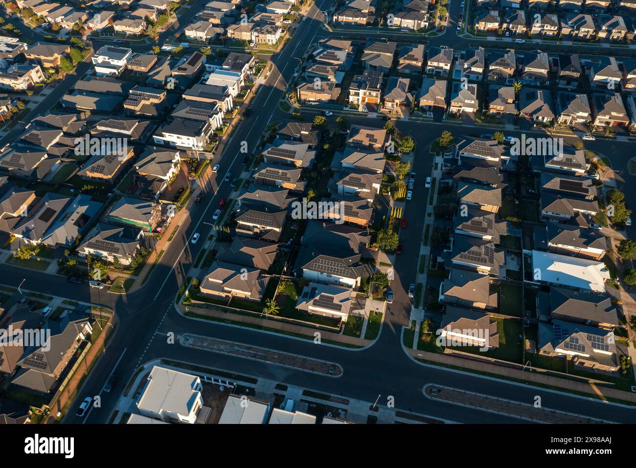 Late afternoon aerial view of streets lined with similar sized modern ...
