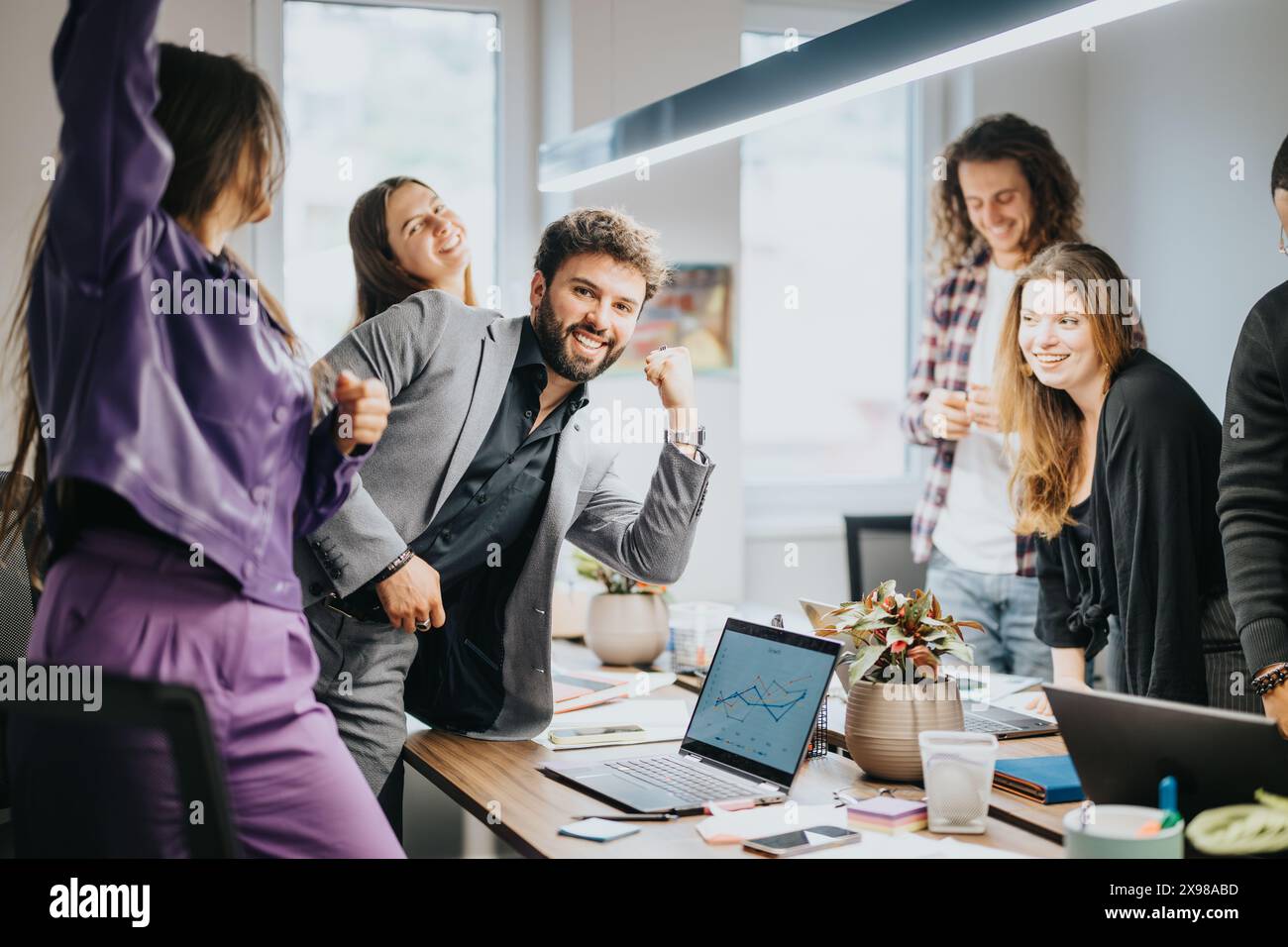 Energetic team celebrating success in creative office meeting Stock ...