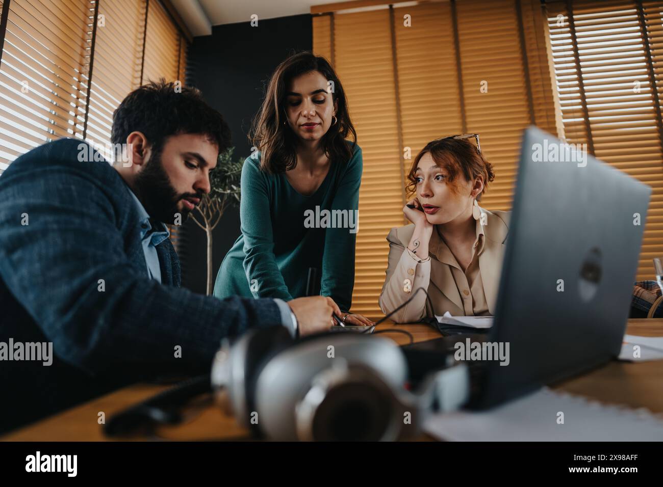 Business associates collaborating in a modern office reviewing papers ...